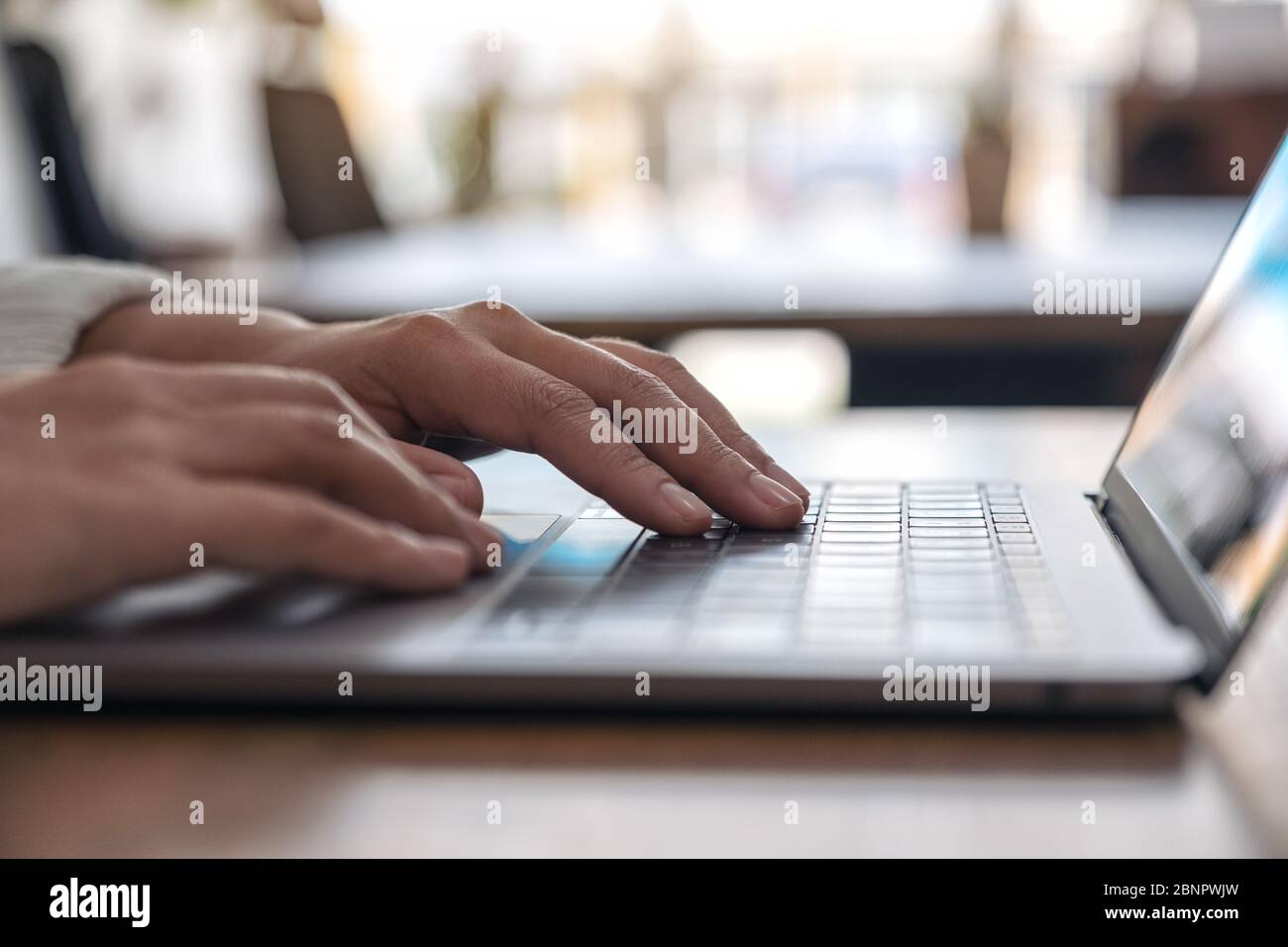 Closeup image of hands using and typing on laptop keyboard on the table ...