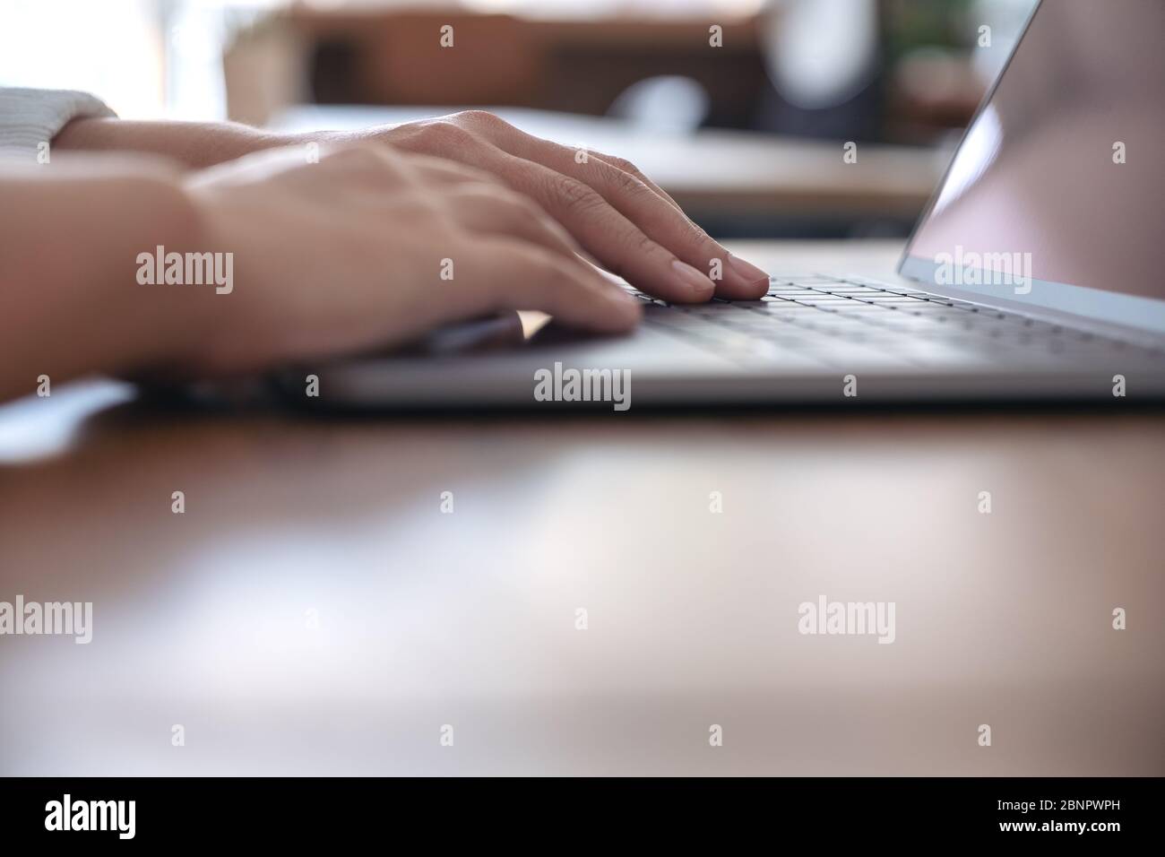 Closeup image of hands using and typing on laptop keyboard on the table ...