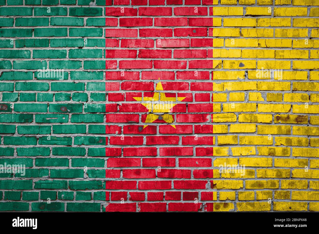 National flag of Cameroon depicting in paint colors on an old brick ...