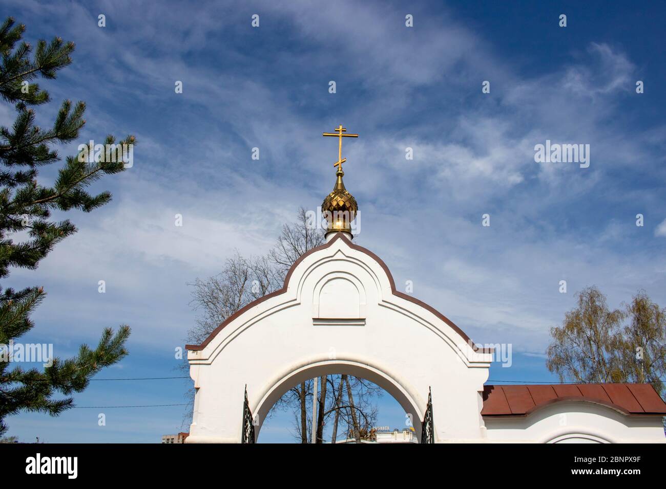 White arch with a dome and cross, entrance to the temple territory ...