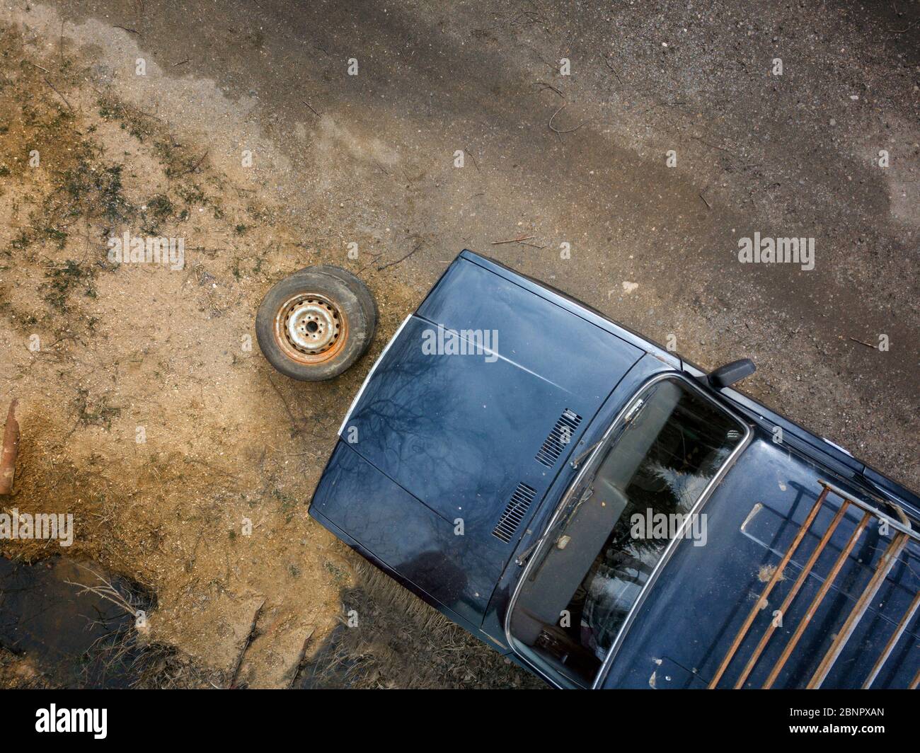 Overhead view of old car on the road side and couple of spare tires ...