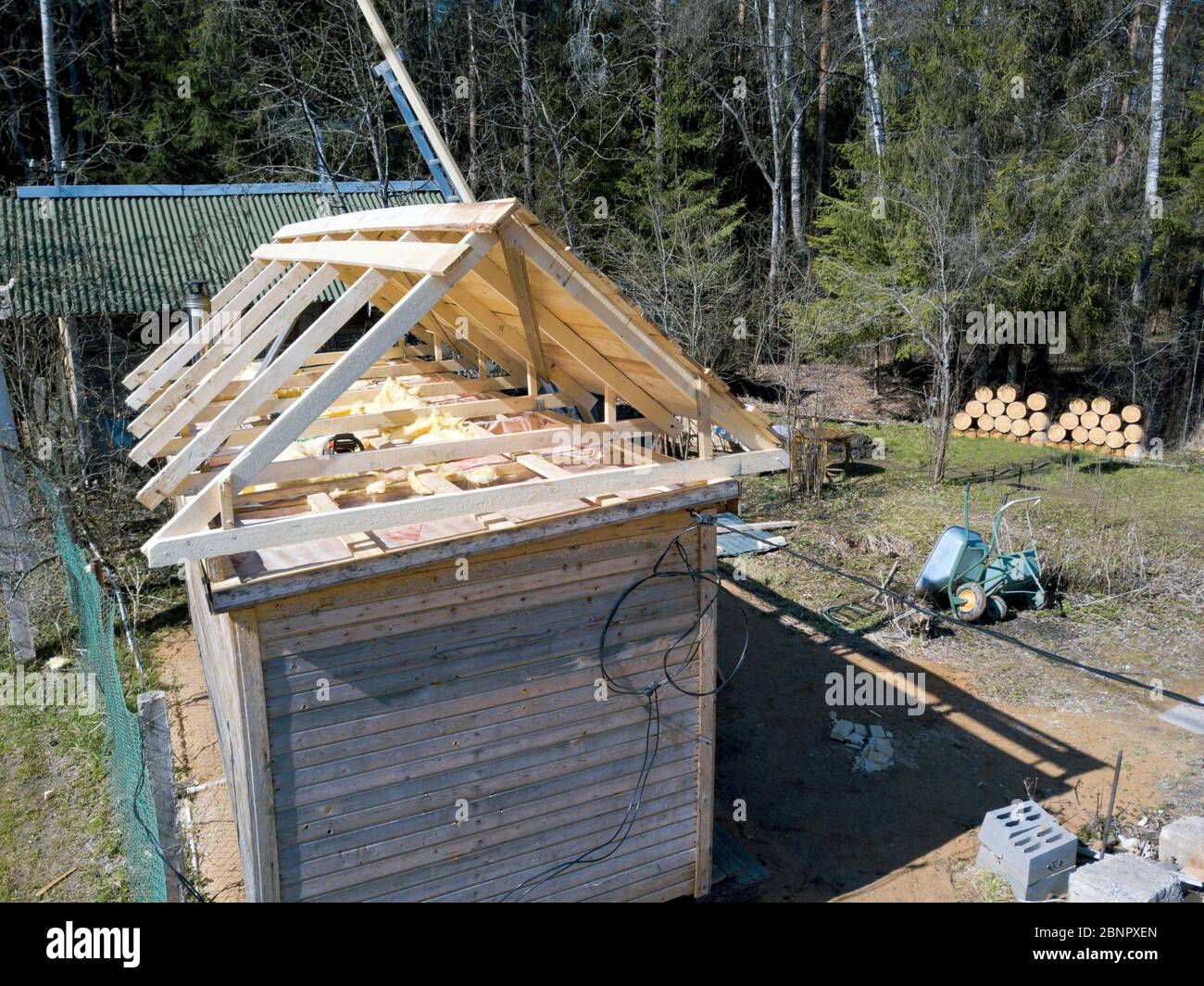 Constructio area in a forest with a new wooden house in the center of ...