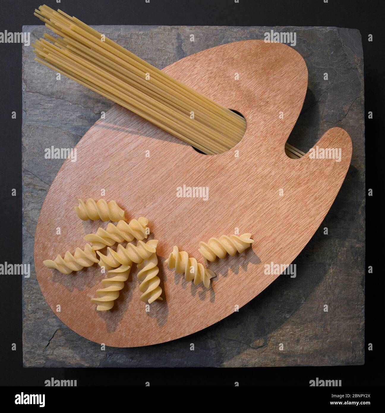 Wooden palette with dried pasta selection against slate background ...