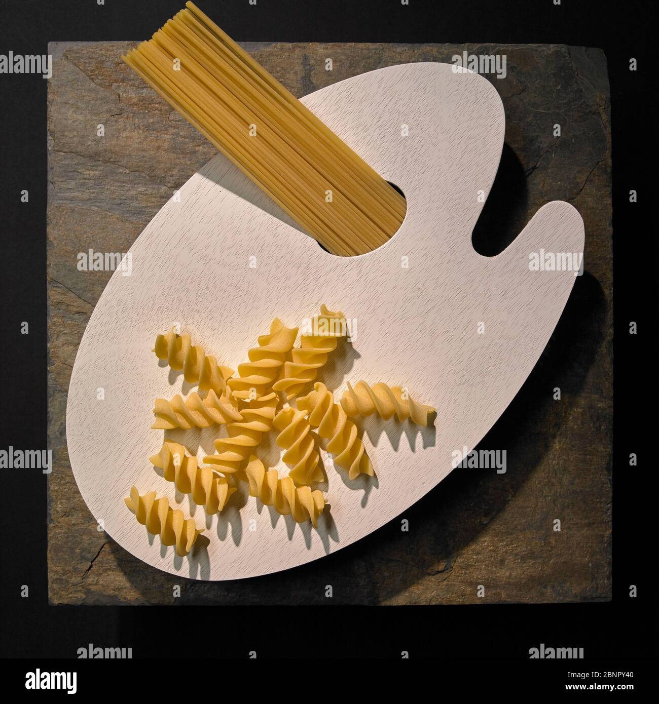 Wooden palette with dried pasta selection against slate background ...