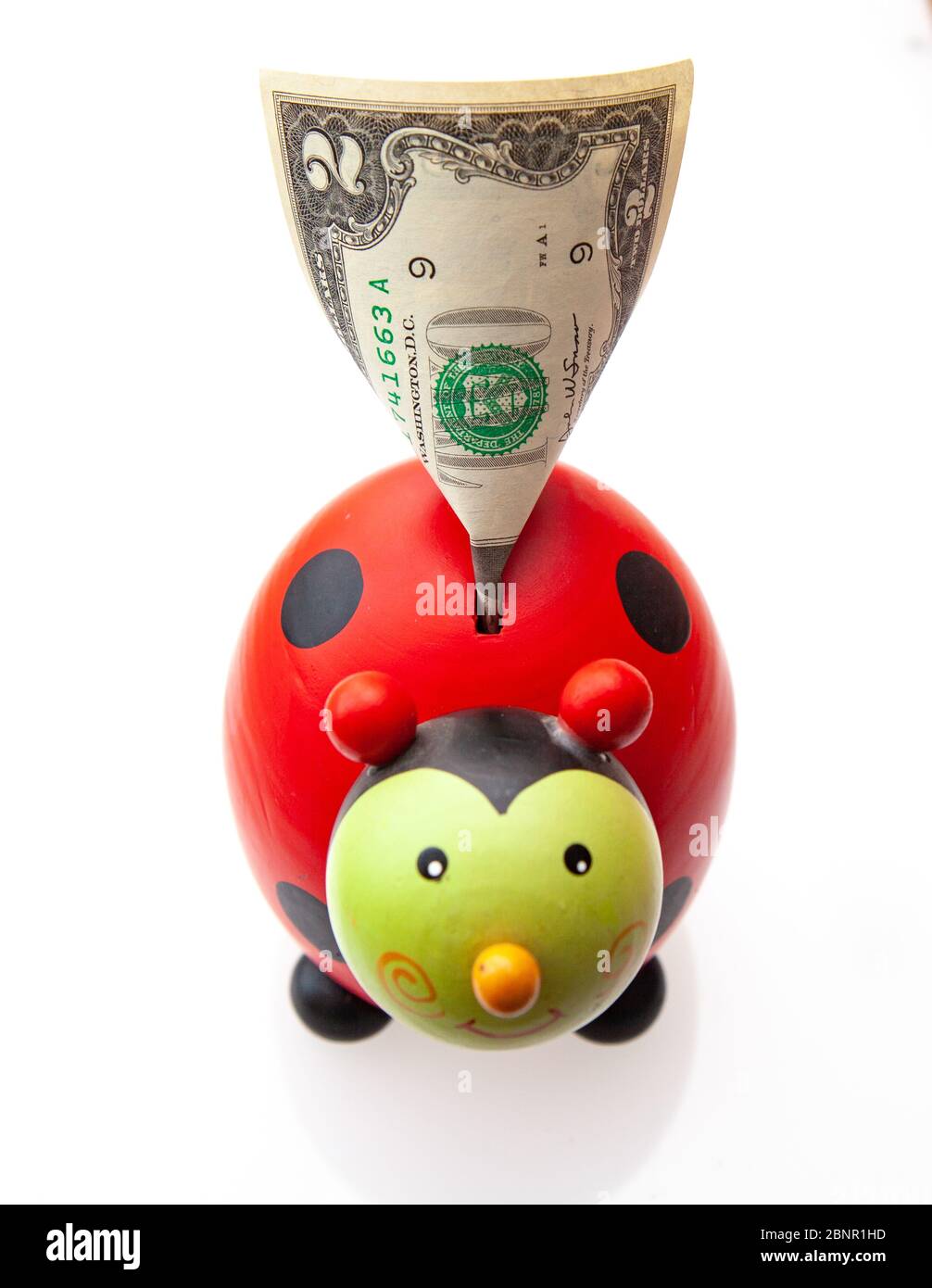 Cute red, black and green lady bug like piggy bank with a two dollar ...