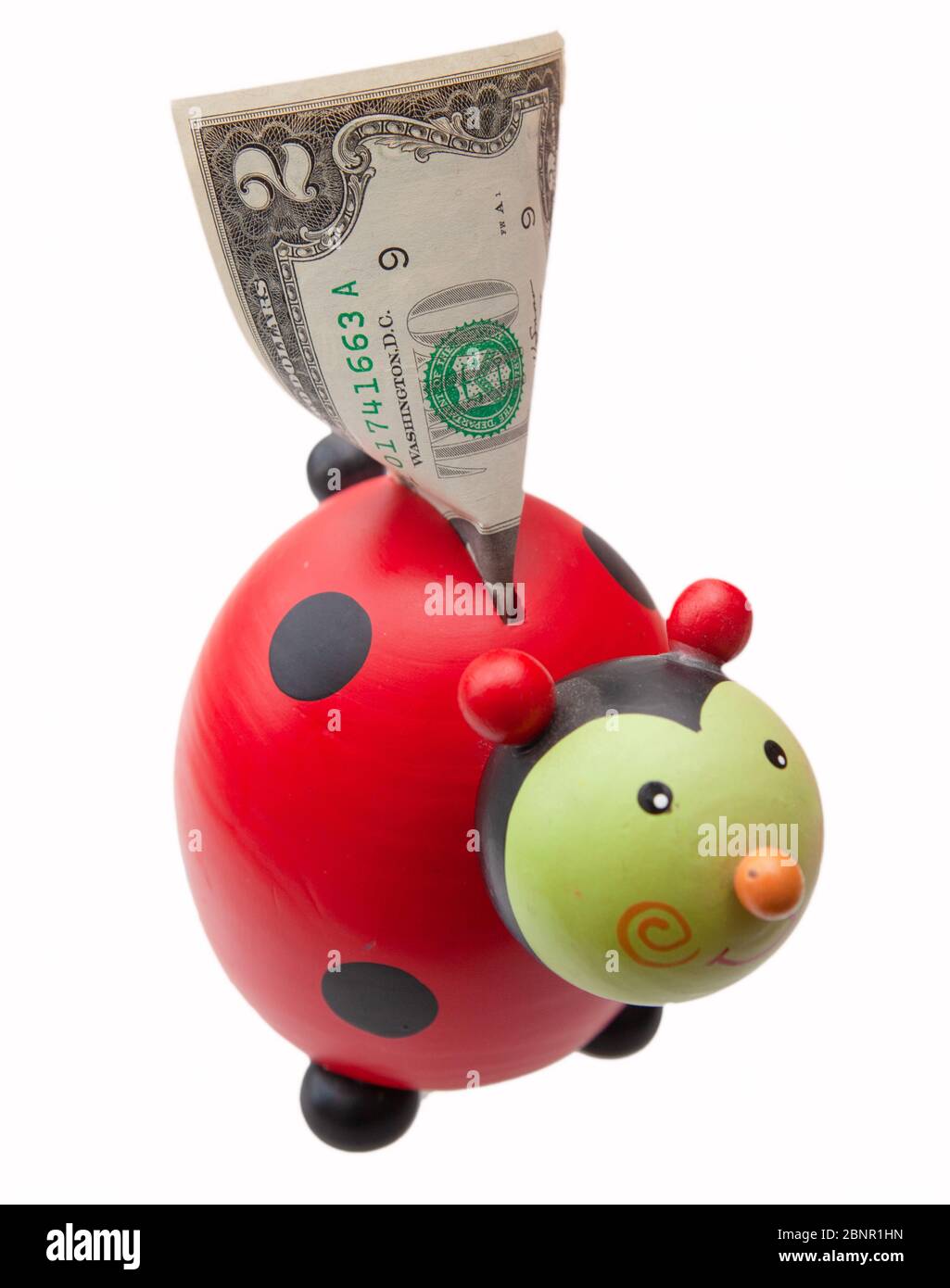 Cute red, black and green lady bug like piggy bank with a two dollar ...