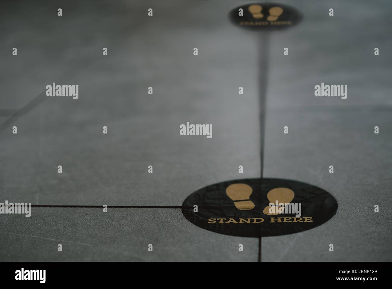 STAND HERE foot sign or symbol on the floor in coffee shop Stock Photo ...