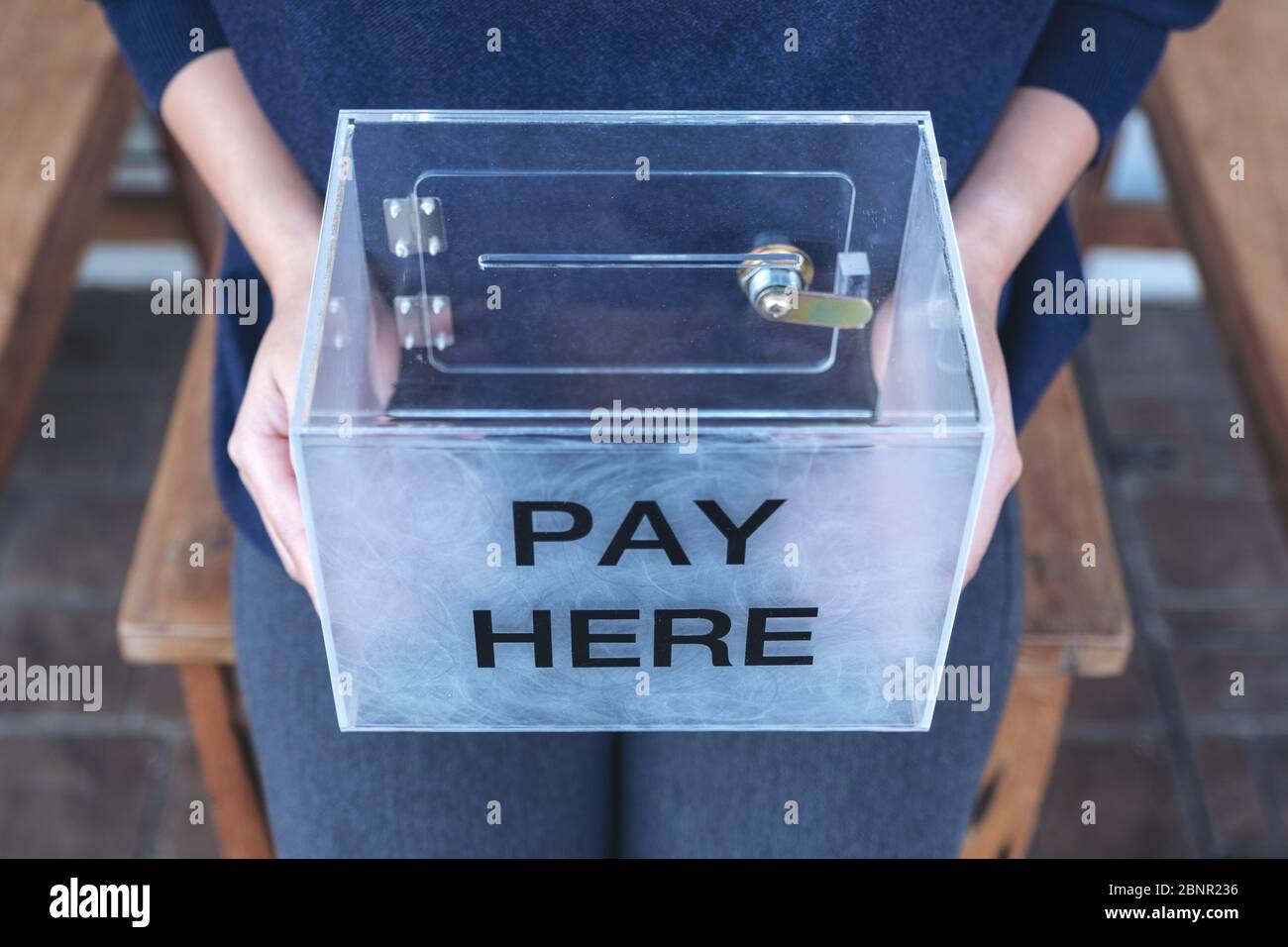Woman putting money into donation box hi-res stock photography and ...