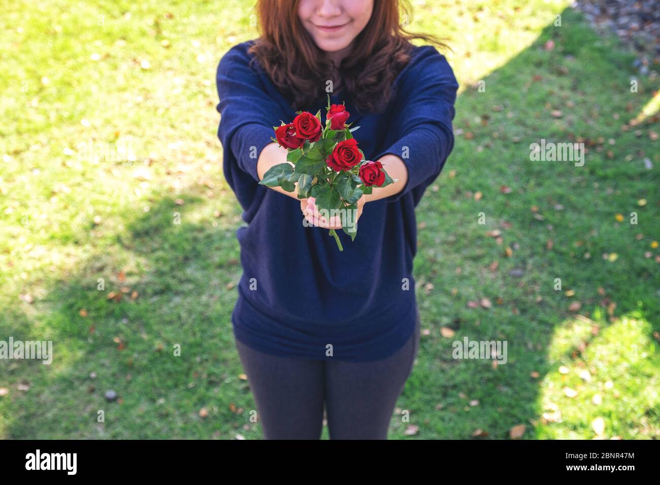 A beautiful asian woman giving red roses flower to her boyfriend on ...