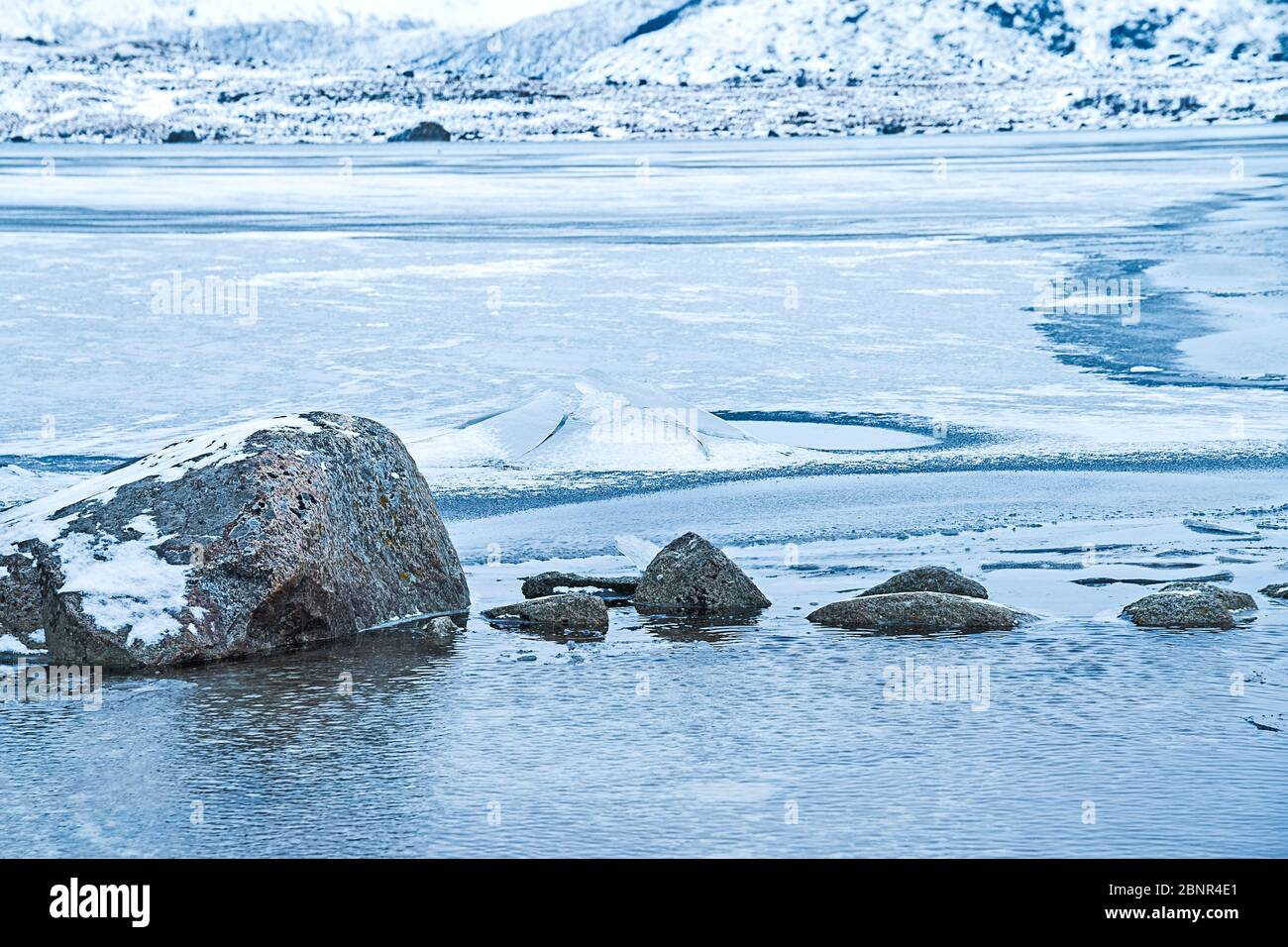 frozen lake with cracked ice Stock Photo - Alamy