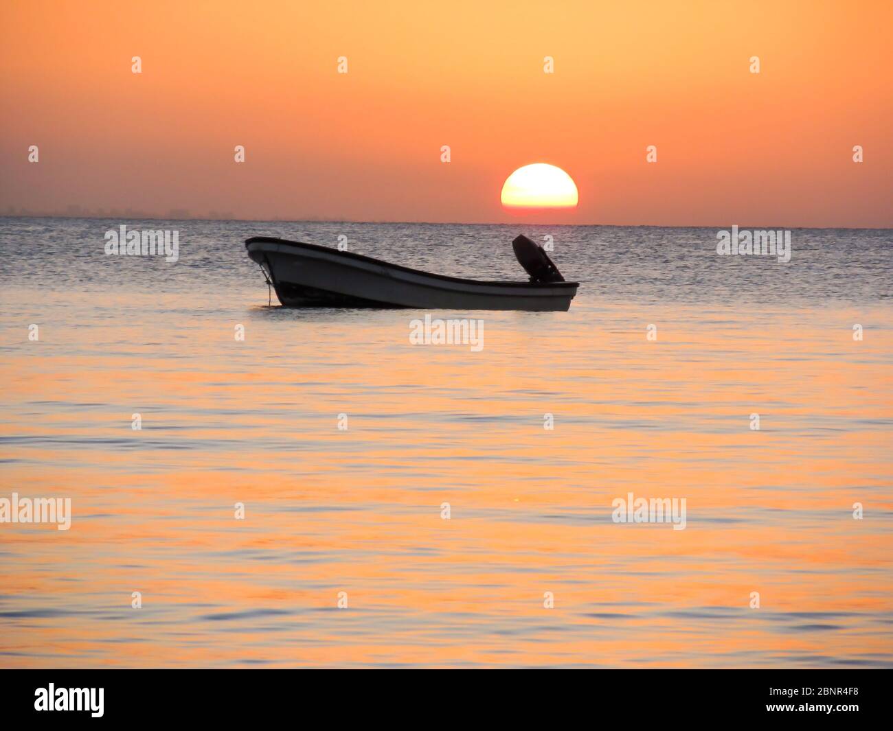 Silhouette of a motorboat in the quiet sheltered water Maputo Bay ...