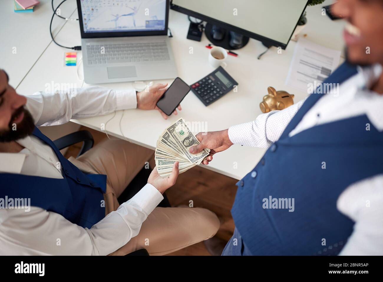 Businessman getting payed for the job well done. Happy colleagues ...