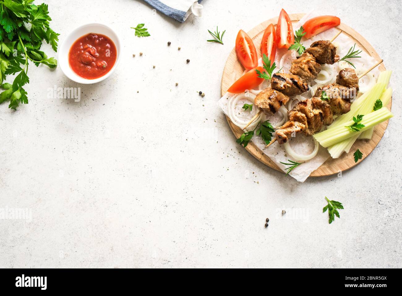 Grilled pork kebabs on skewers on white background, top view, copy space. Meat pork, chicken or ...