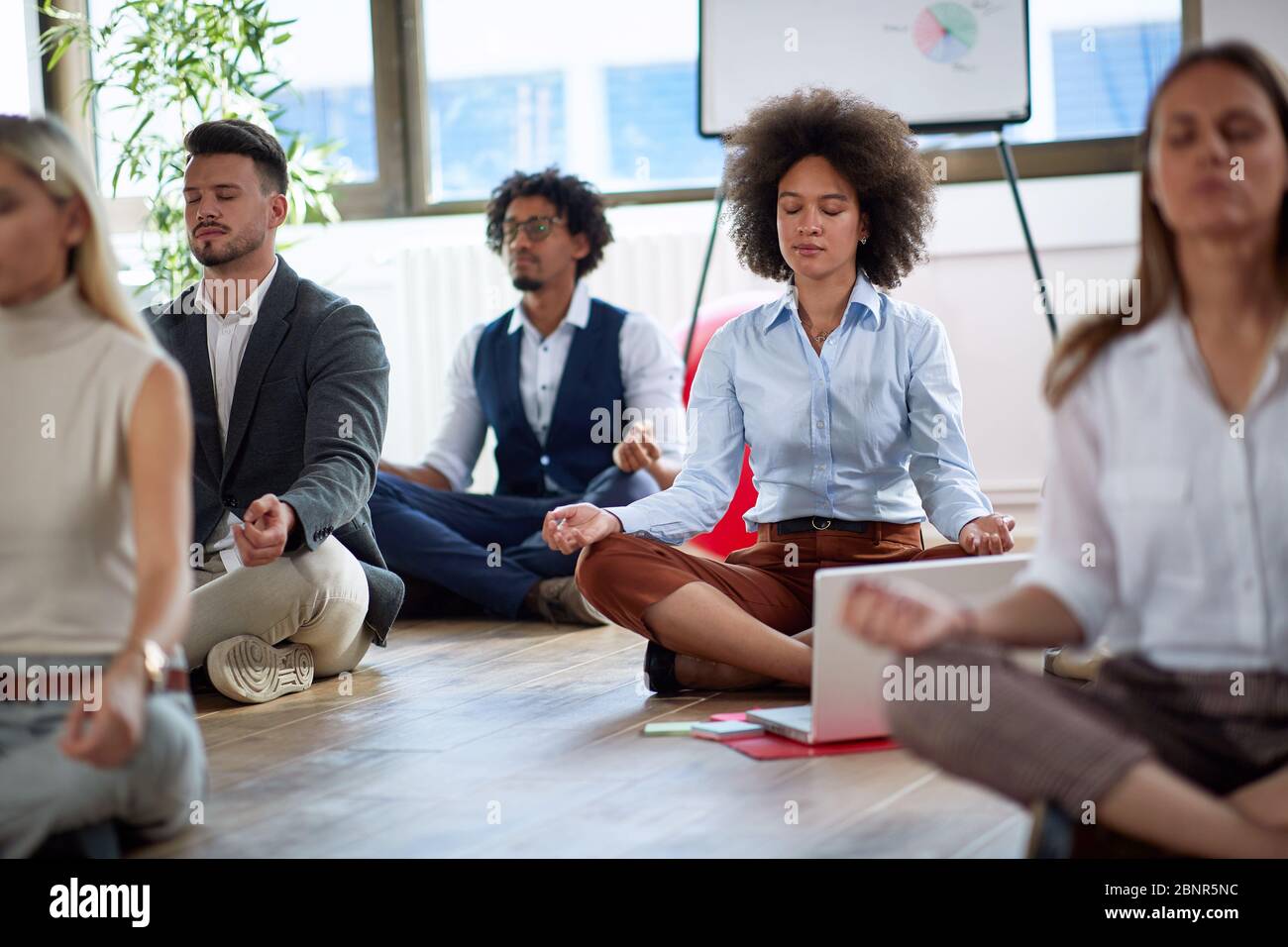 Office employees taking a break to do a meditation. Coworkers ...