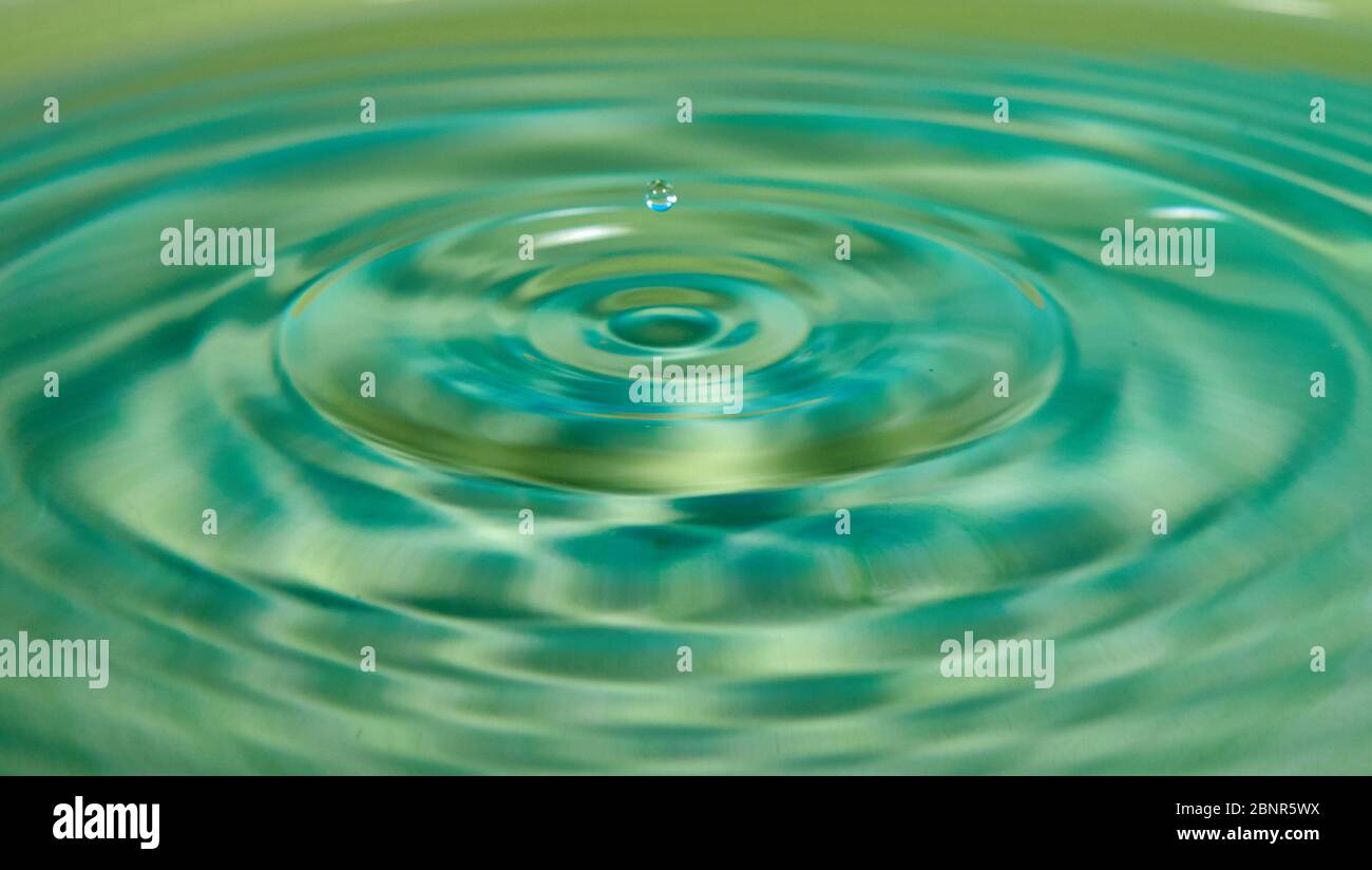 Drop of water or fluid created a ripple wave Stock Photo - Alamy