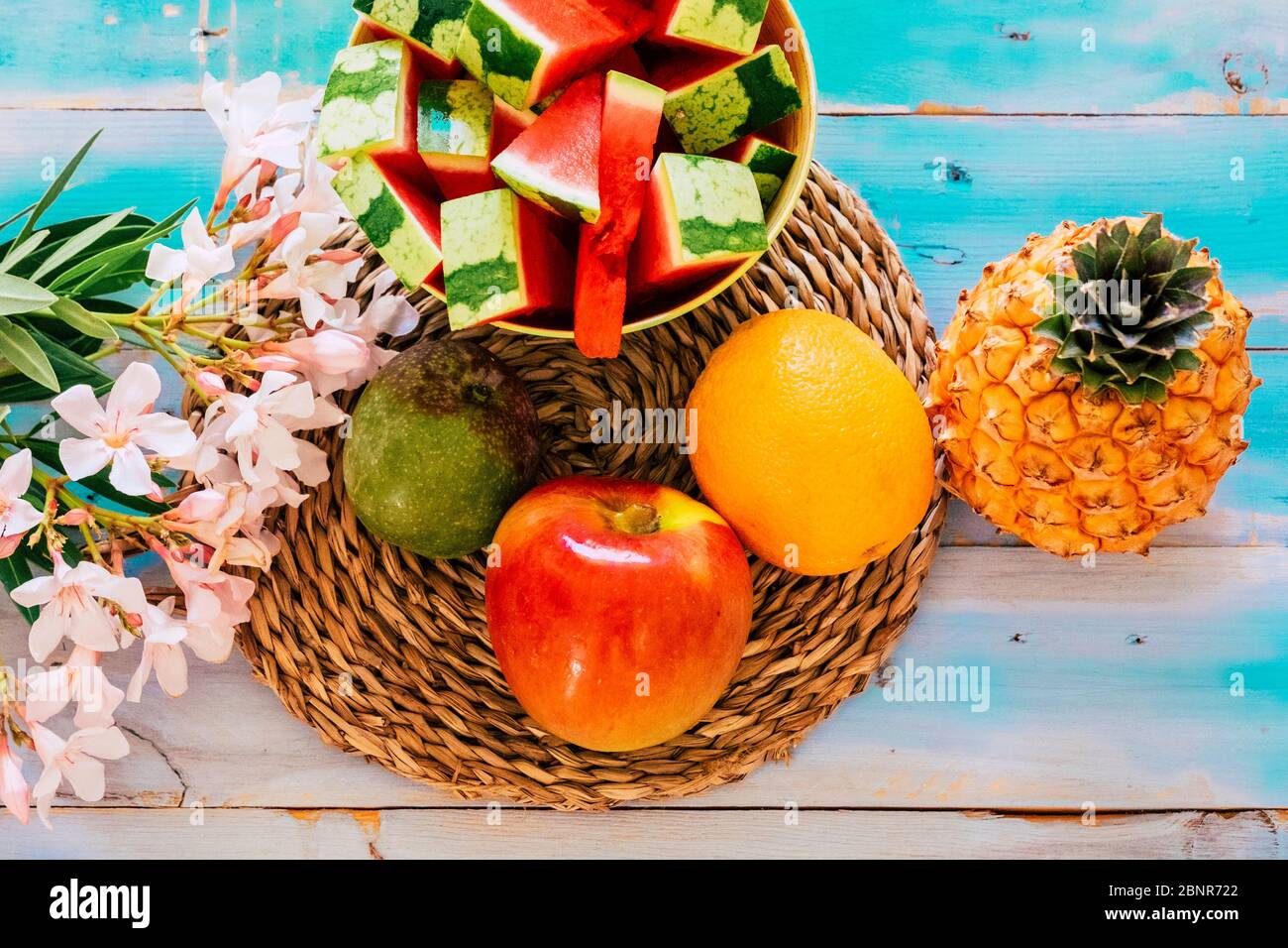 coloured above view of mixed tasty fruits on a blue wooden table ...