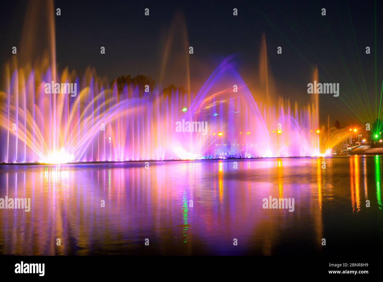 Summer night. Laser show and color fountain Stock Photo - Alamy