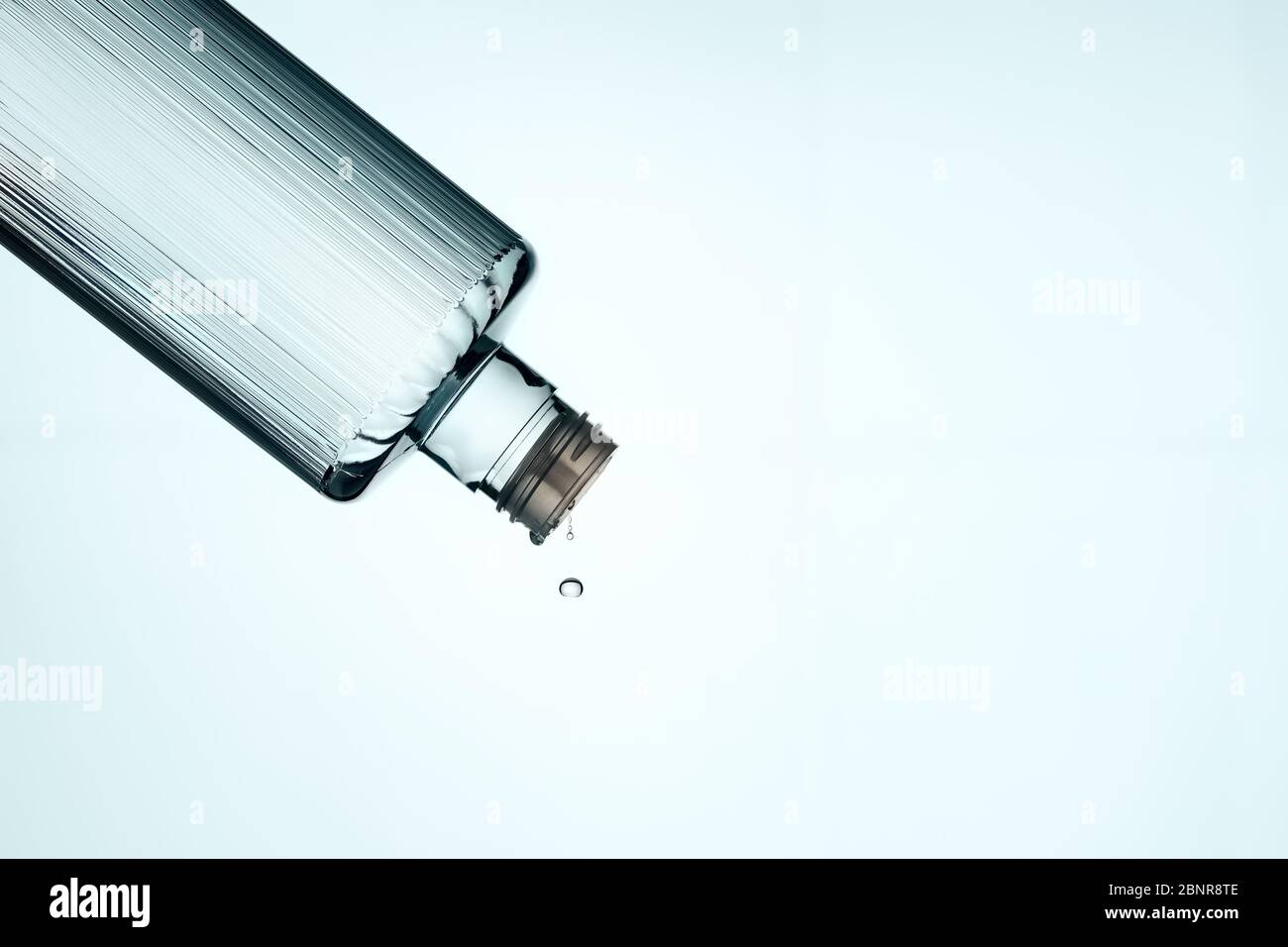 Traditional Turkish cologne dripping from a bottle on white background ...