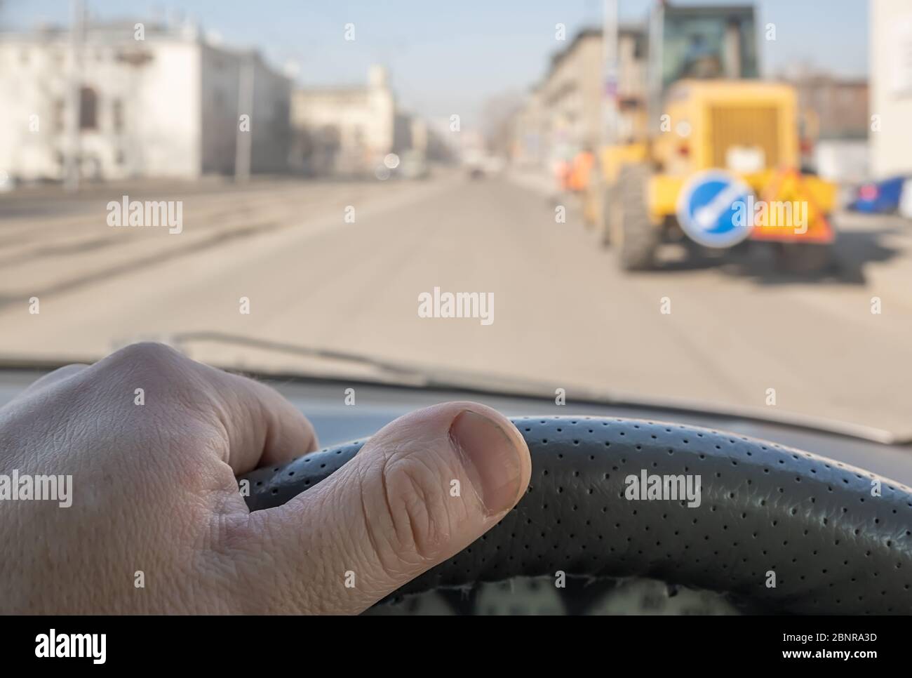 view of the driver hand on the steering wheel of a car passing through ...