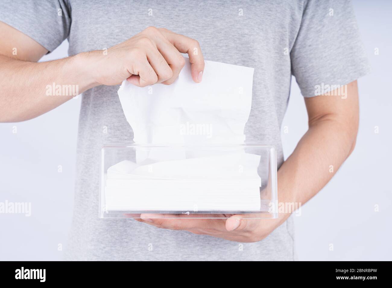 Delicate male hands pulling a white tissue paper out of a transparent ...