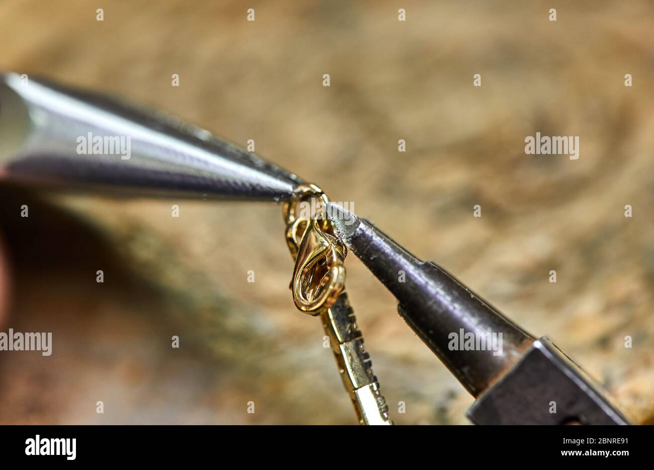 Jewelry production. The process of connecting a golden lock with a ...