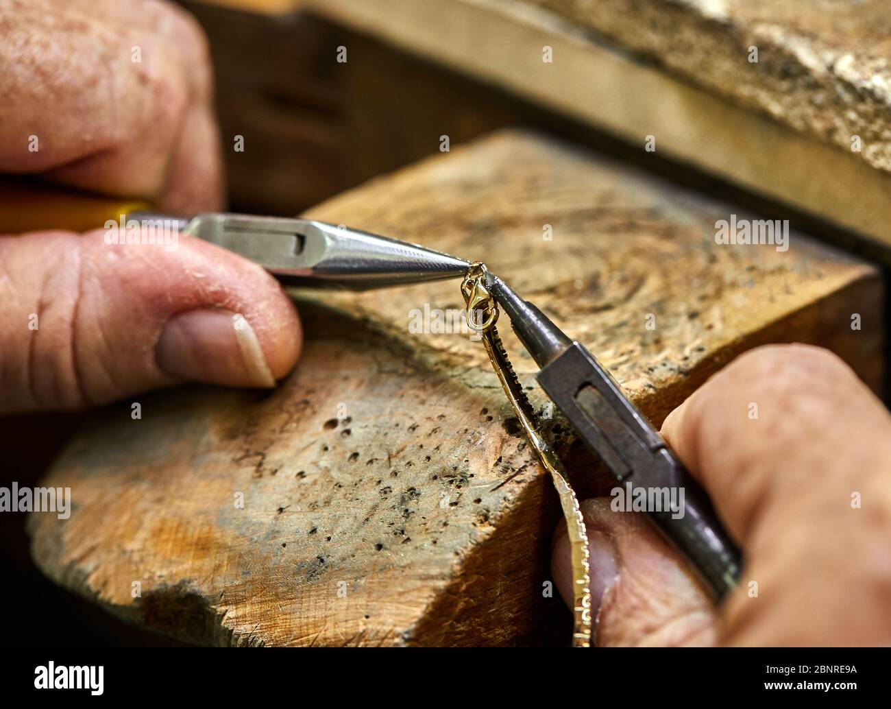Jewelry production. The process of connecting a golden lock with a ...