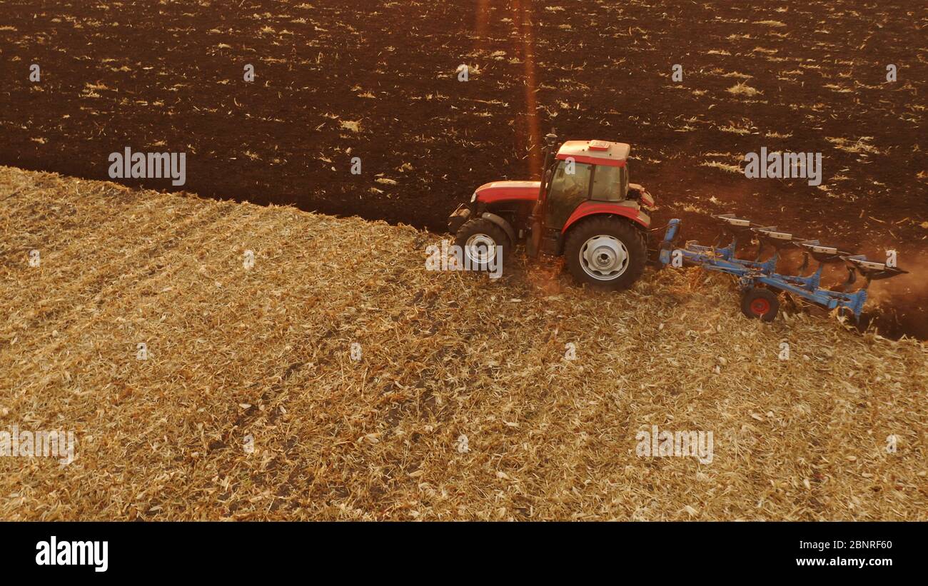 Agricultural background with tractor working on field Stock Photo - Alamy