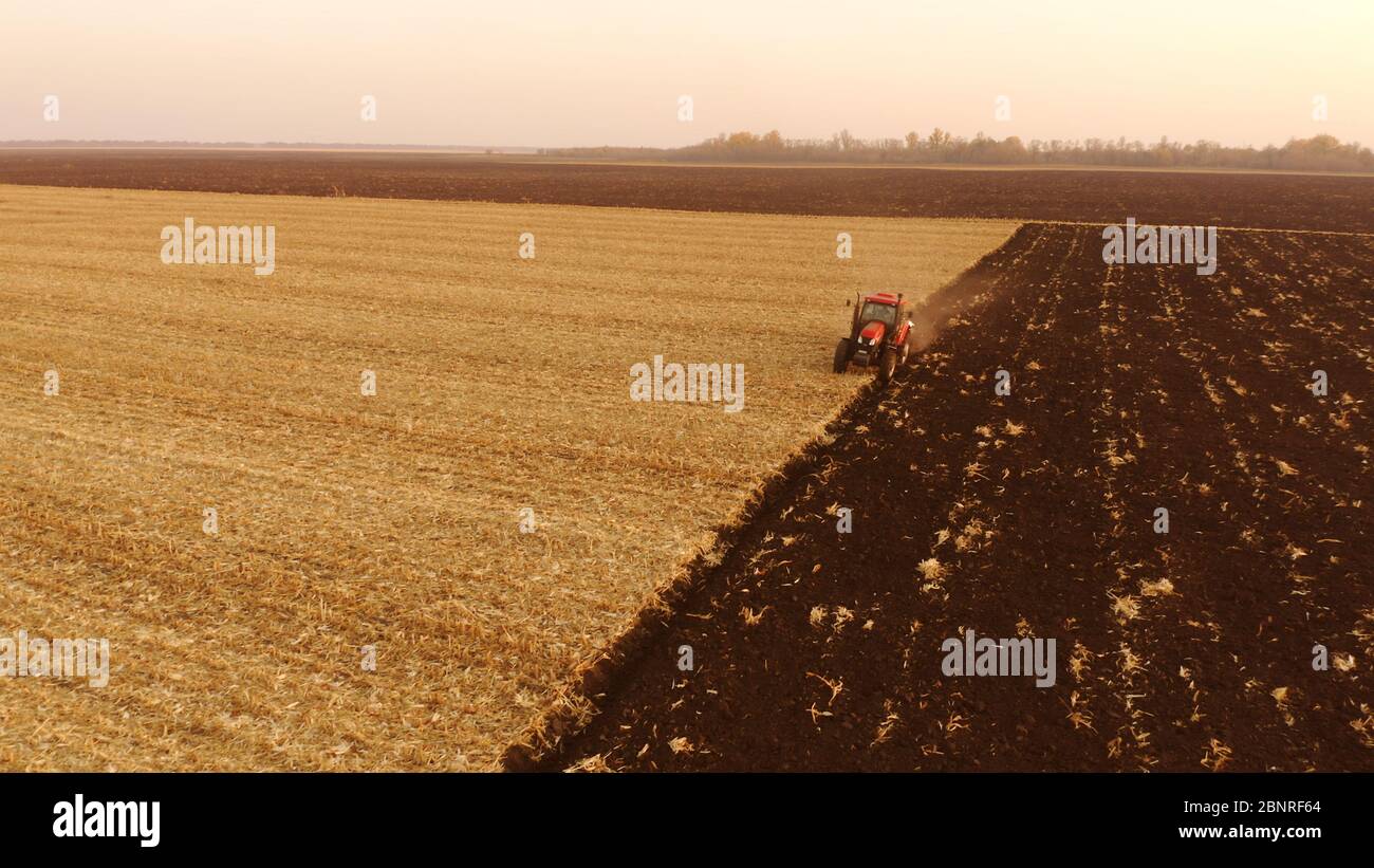 Tractor plowing big farm field Stock Photo - Alamy