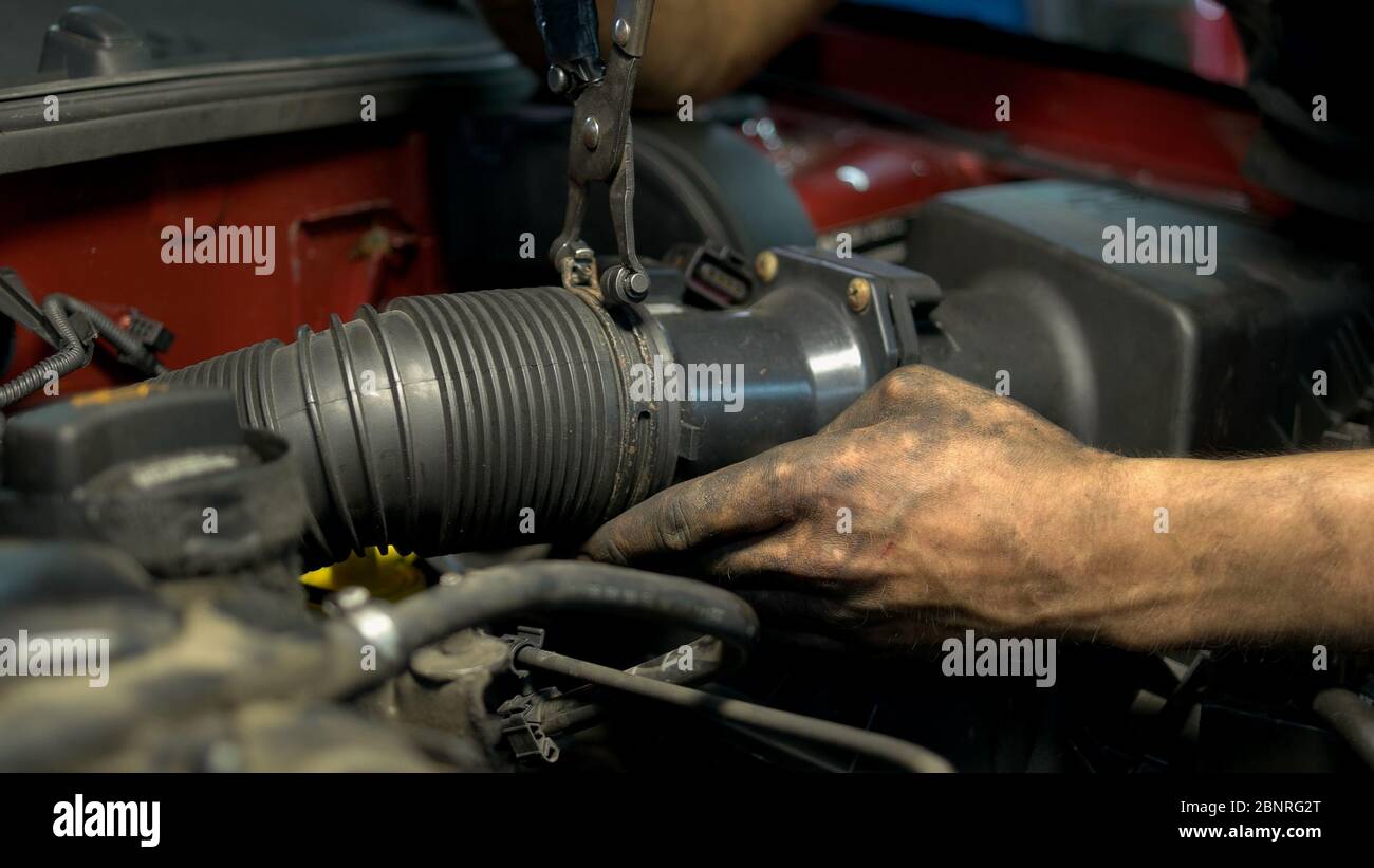 Close up worker installing car engine hose Stock Photo - Alamy