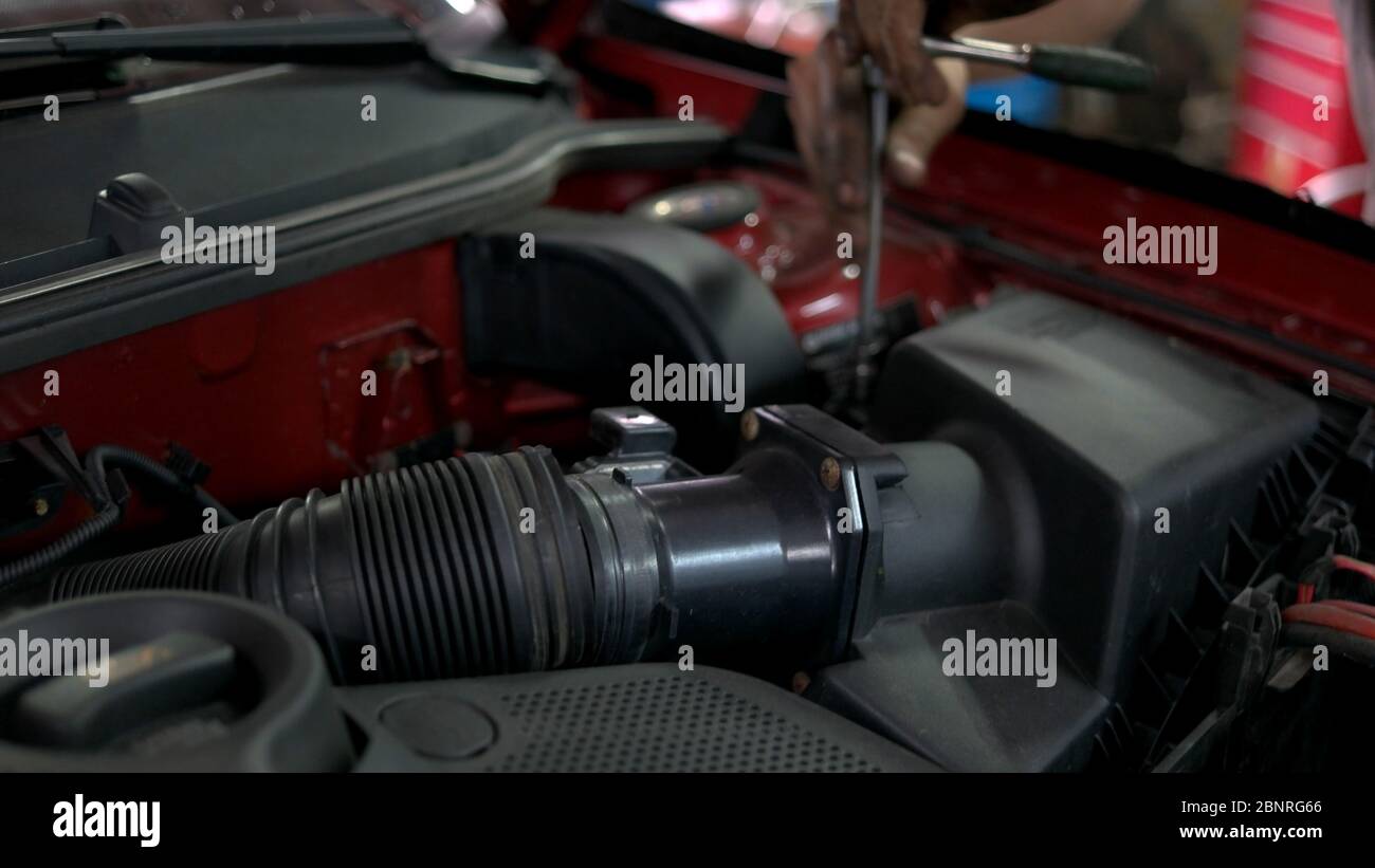 Repairman unscrewing and withdrawing big car engine detail Stock Photo ...