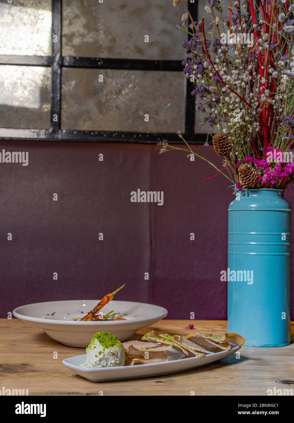 Dishes served in restaurant as menu starters on wooden table and vase ...