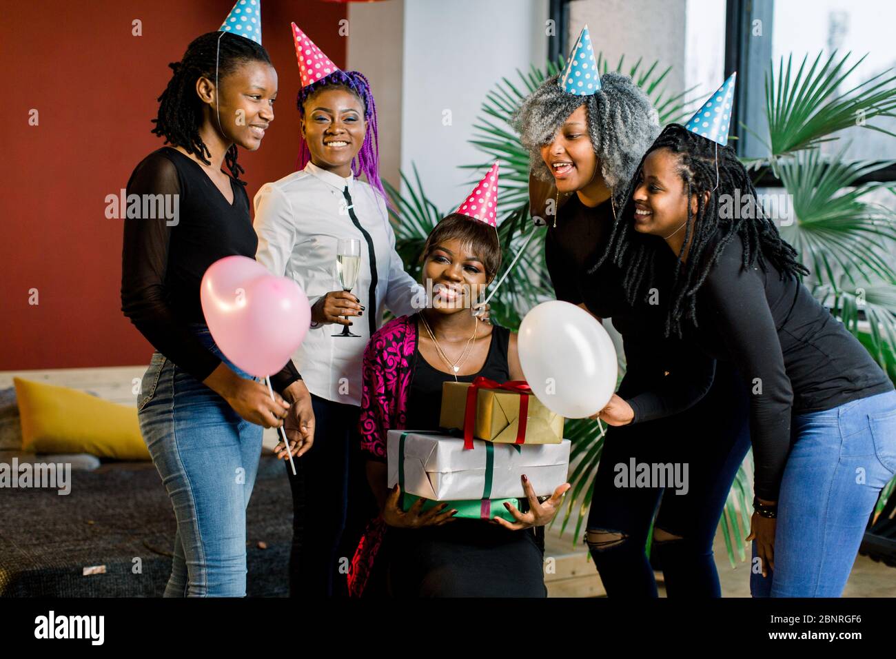 Happy group African girls with colorful presents and balloons in hands ...