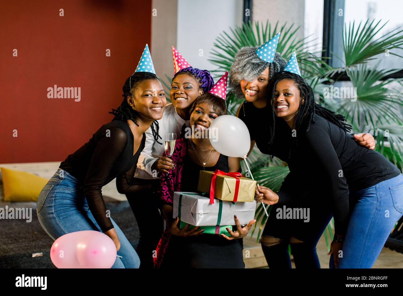 Happy group African girls with colorful presents and balloons in hands ...