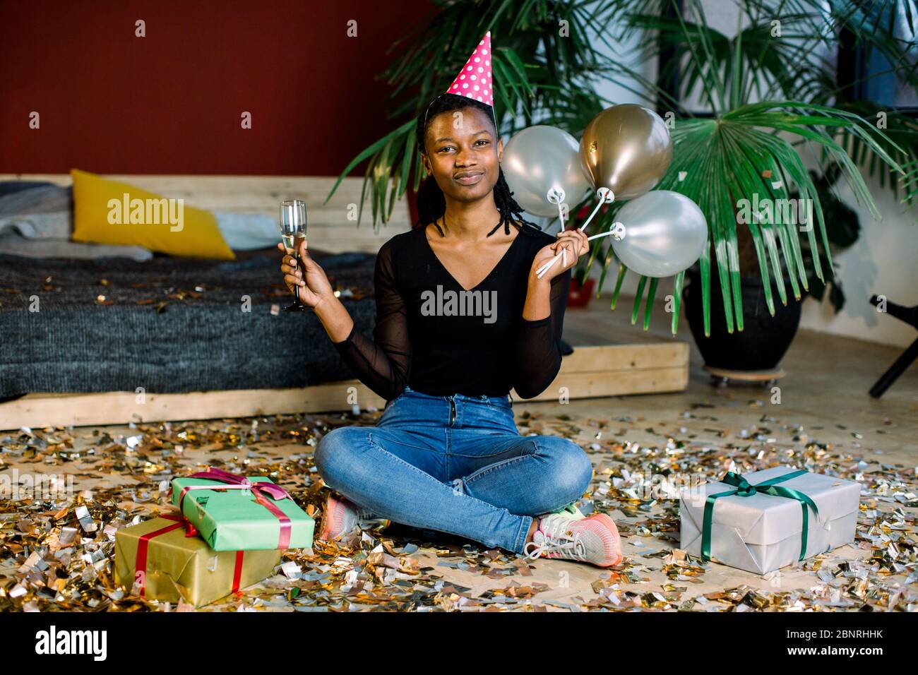Funny African American girl in birthday hat and with air balloons ...