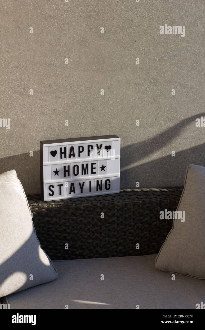 At home on the balcony, sign 'happy home staying' Stock Photo - Alamy