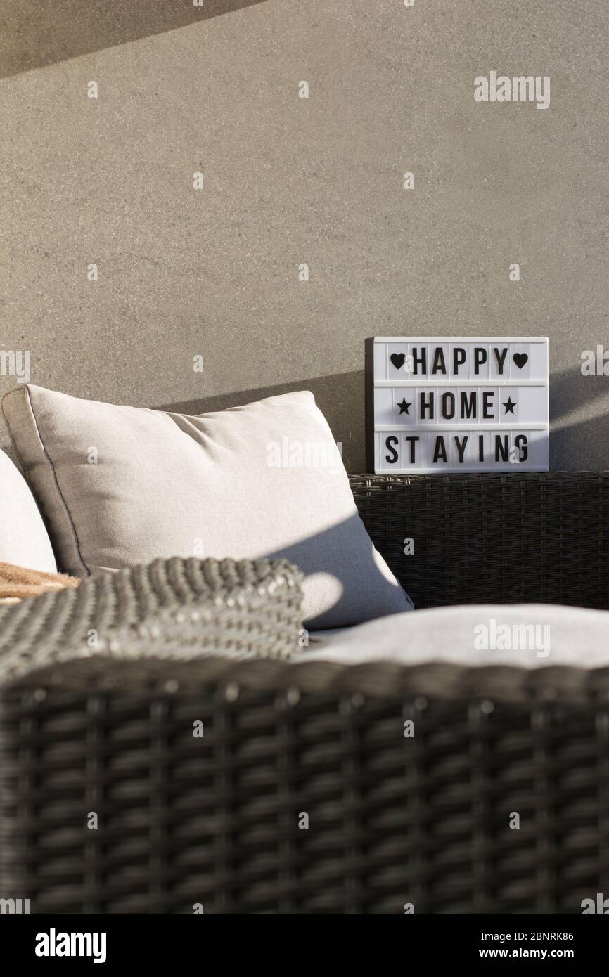 At home on the balcony, sign 'happy home staying' Stock Photo - Alamy