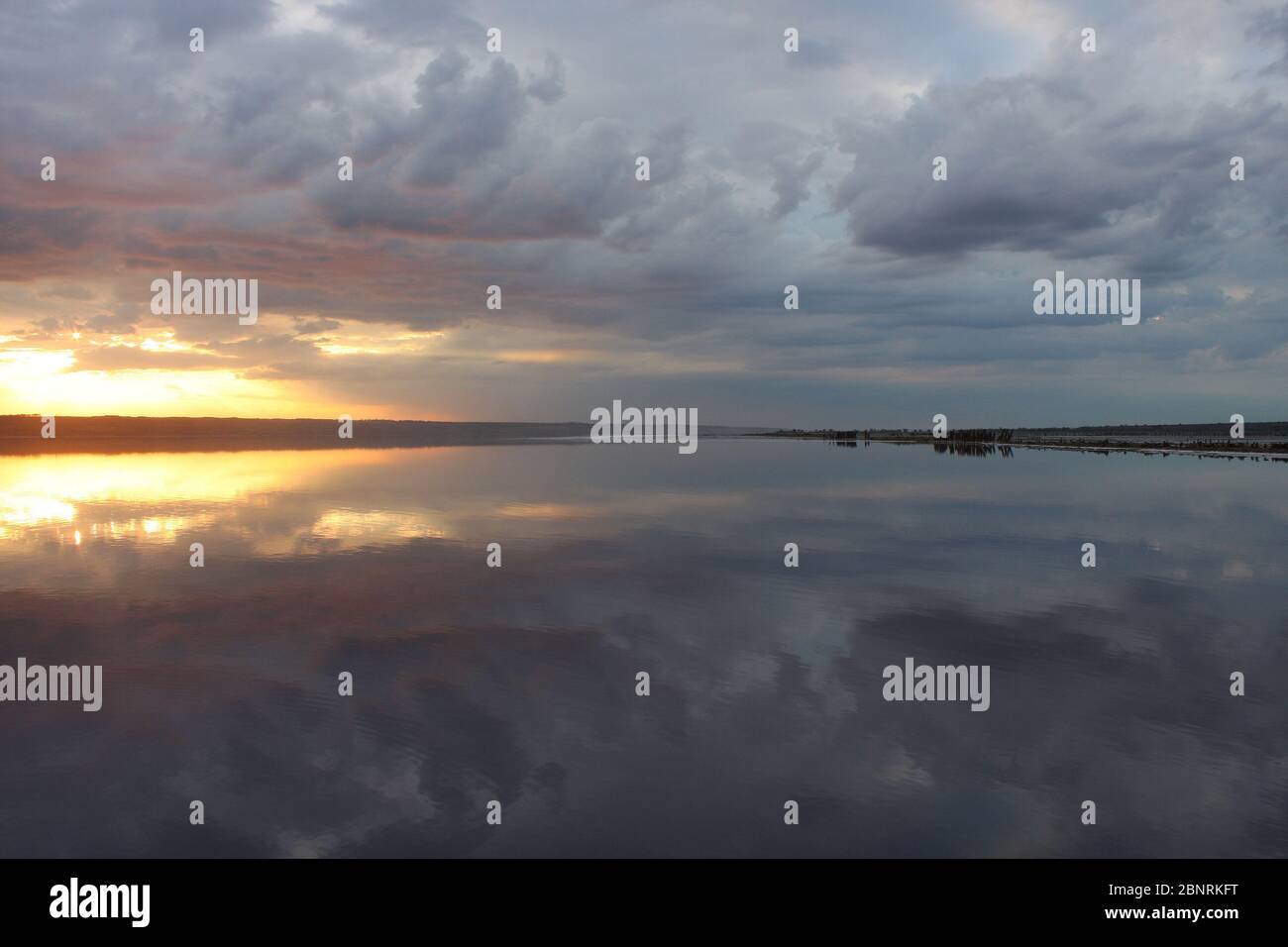 yellow sunset with clouds on the coast Stock Photo - Alamy