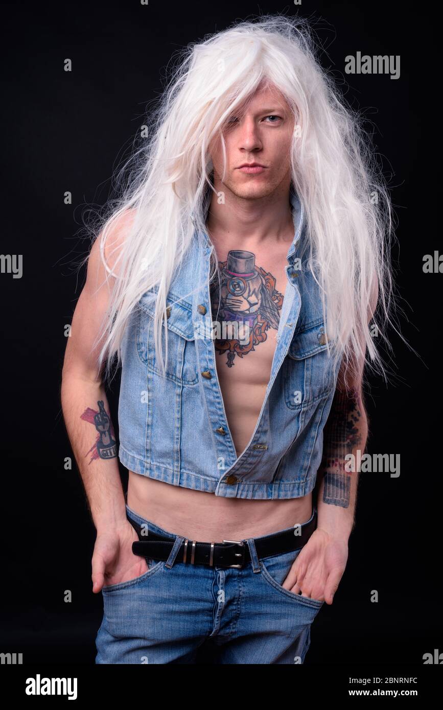Punk rocker man wearing wig against black background Stock Photo - Alamy