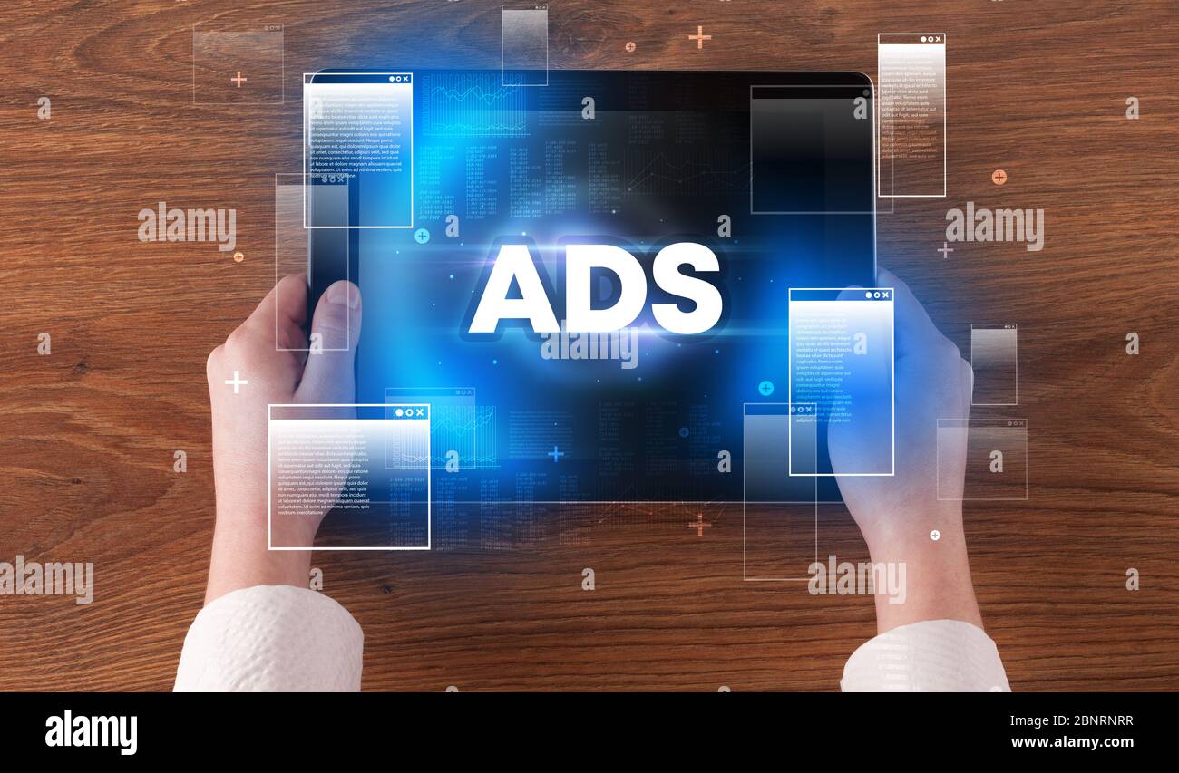 Close-up of a hand holding tablet with ADS abbreviation, modern ...
