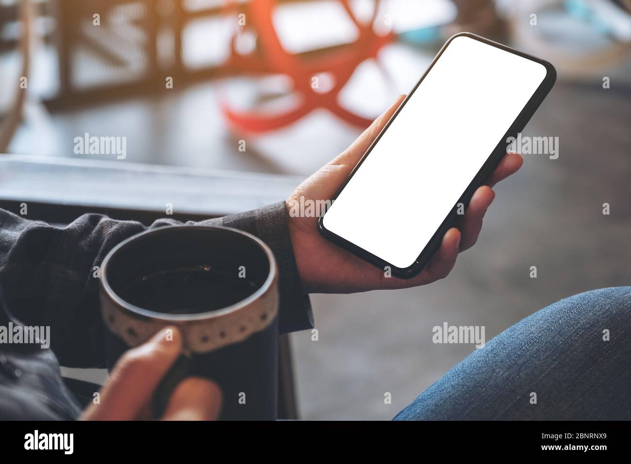 Mockup image of a hand holding black mobile phone with blank screen ...