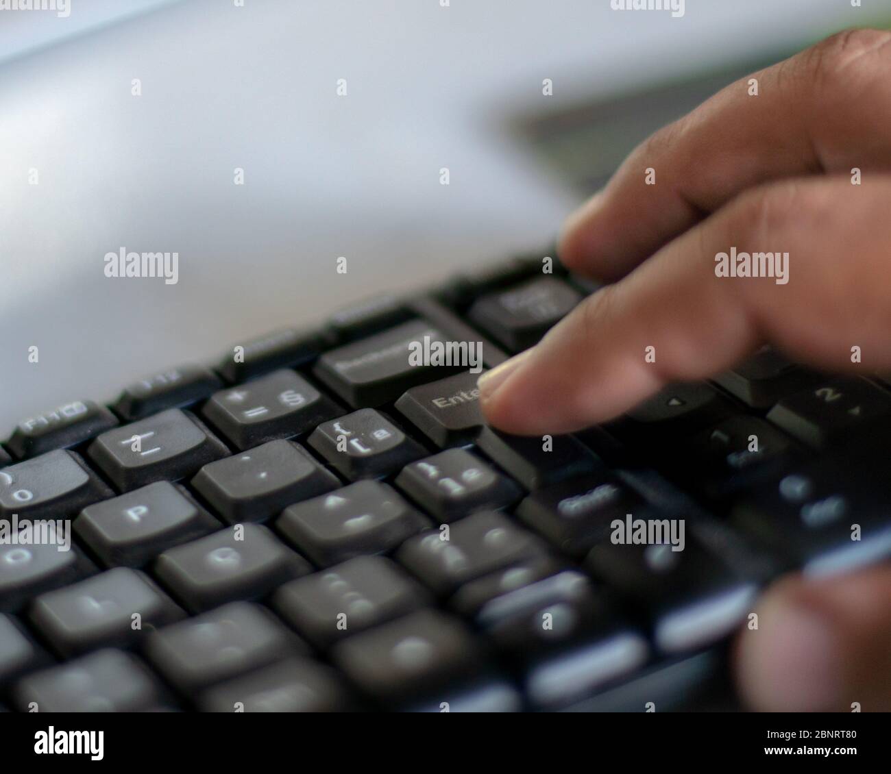 Finger on the enter key - hand pressing "enter" button on computer ...