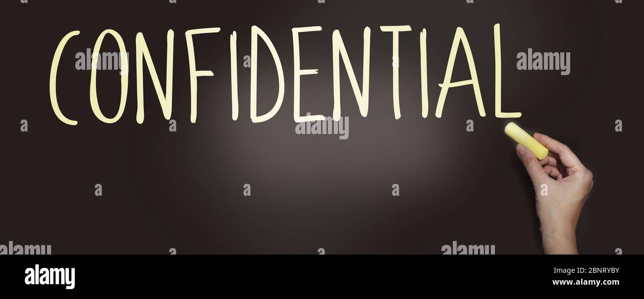 The word Confidential handwritten with white chalk on a blackboard ...