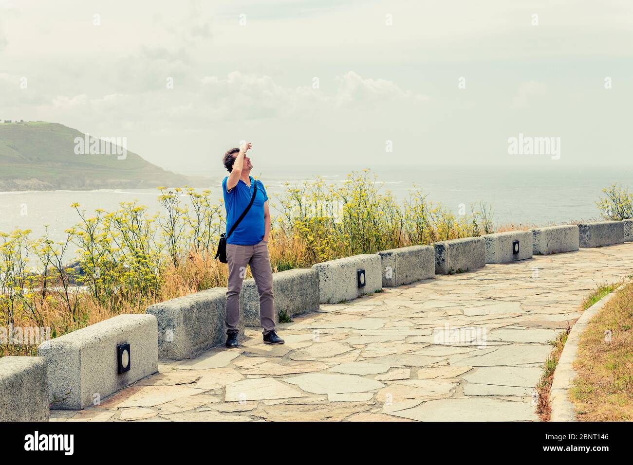 man standing on a stone path looking curiously at the sky Stock Photo ...