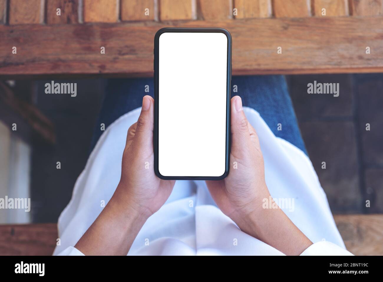 Top view mockup image of hands holding black mobile phone with blank ...