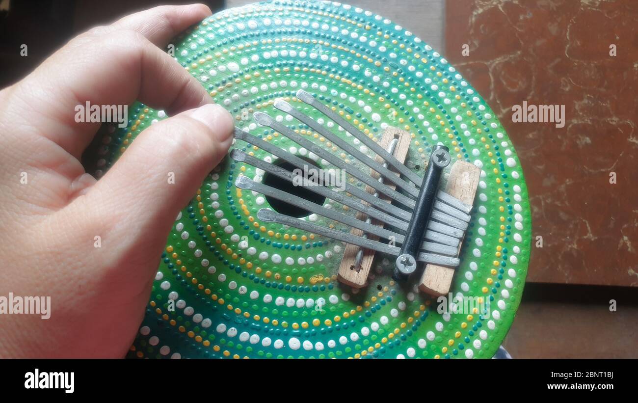 Hand playing the coconut kalimba. Closeup Stock Photo - Alamy