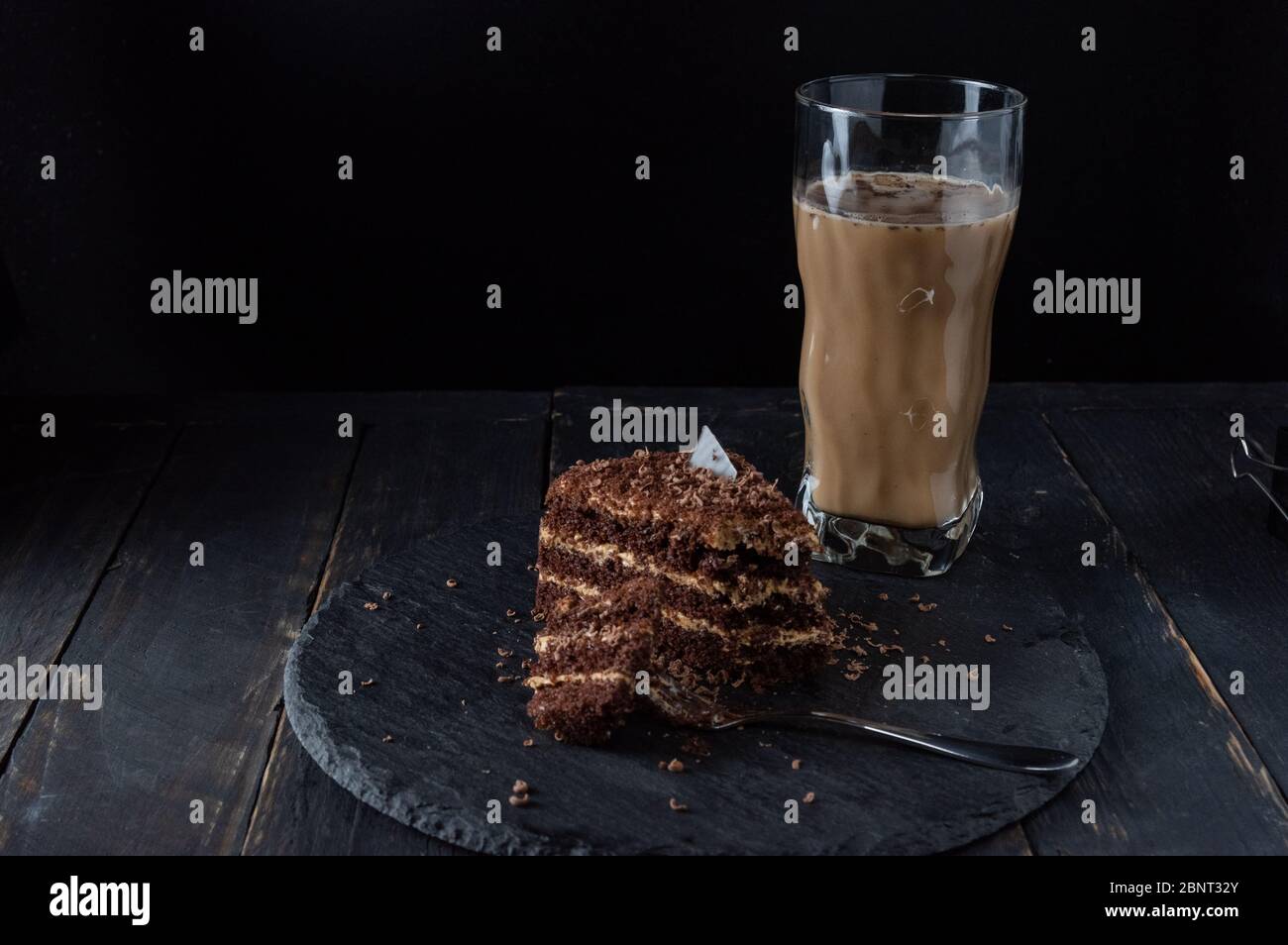 Bitten chocolate cake and latte. Slice of cake and dessert fork. Latte ...