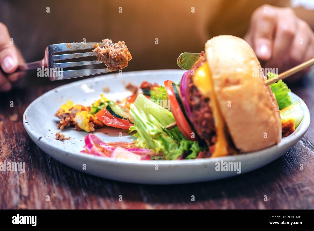 woman eating beef hamburger with knife and fork in the restaurant Stock ...