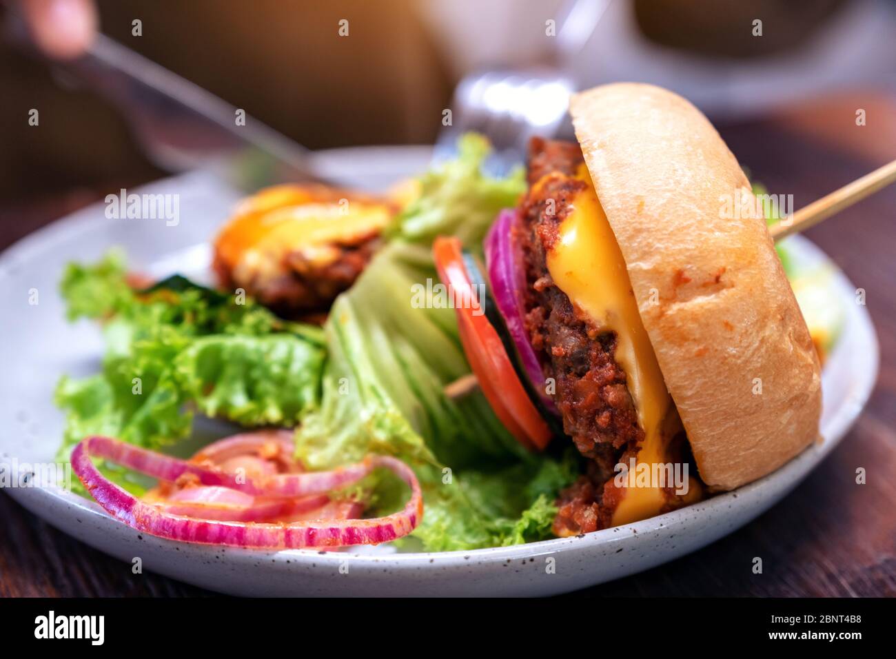 woman eating beef hamburger with knife and fork in the restaurant Stock ...