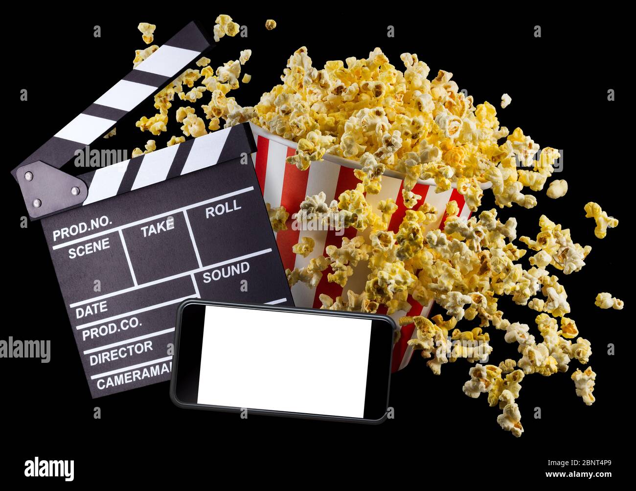 Flying popcorn, film clapper board and phone isolated on black ...