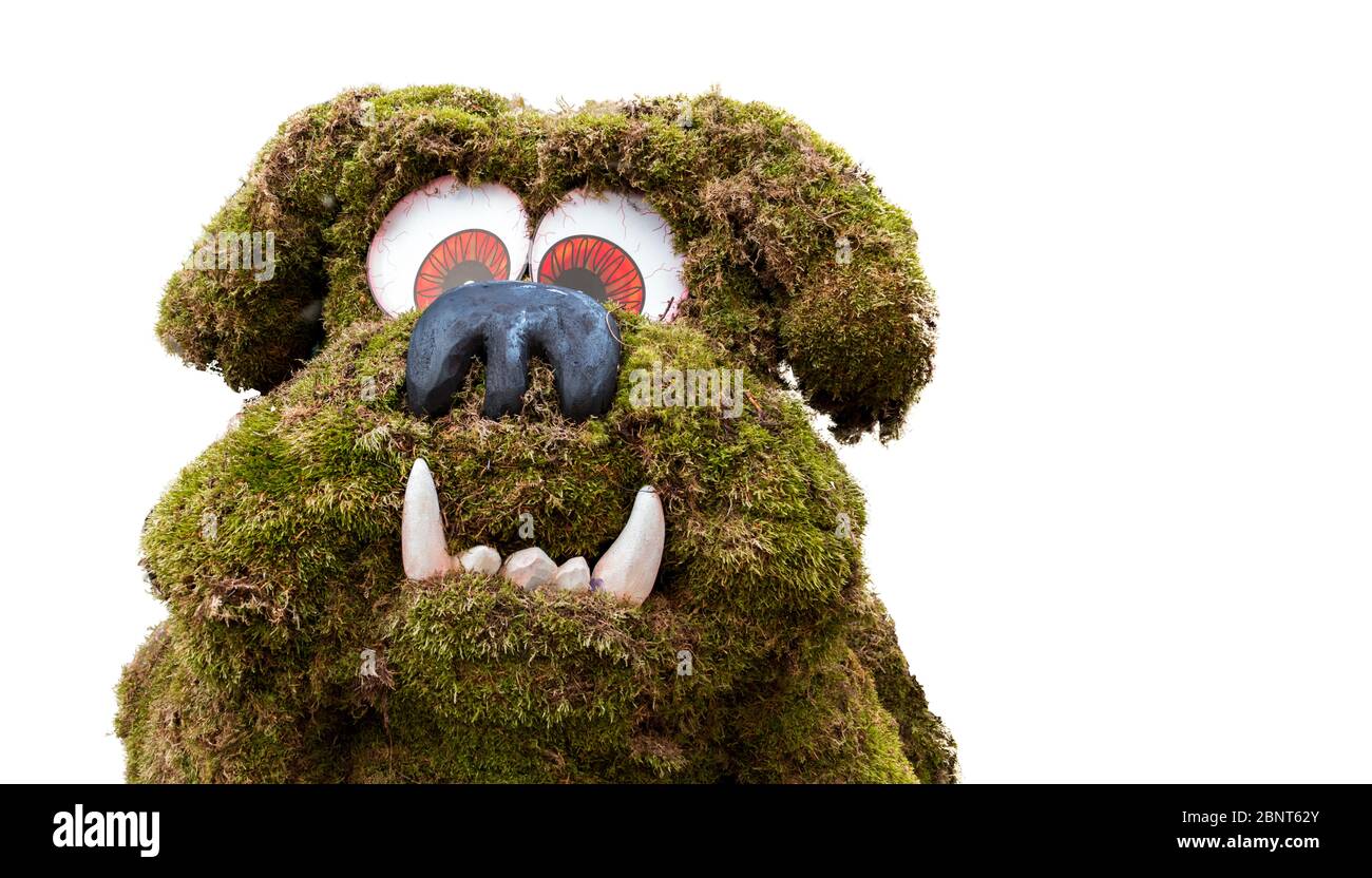 A dog figure made with artificial turf big eyes and big fangs over ...